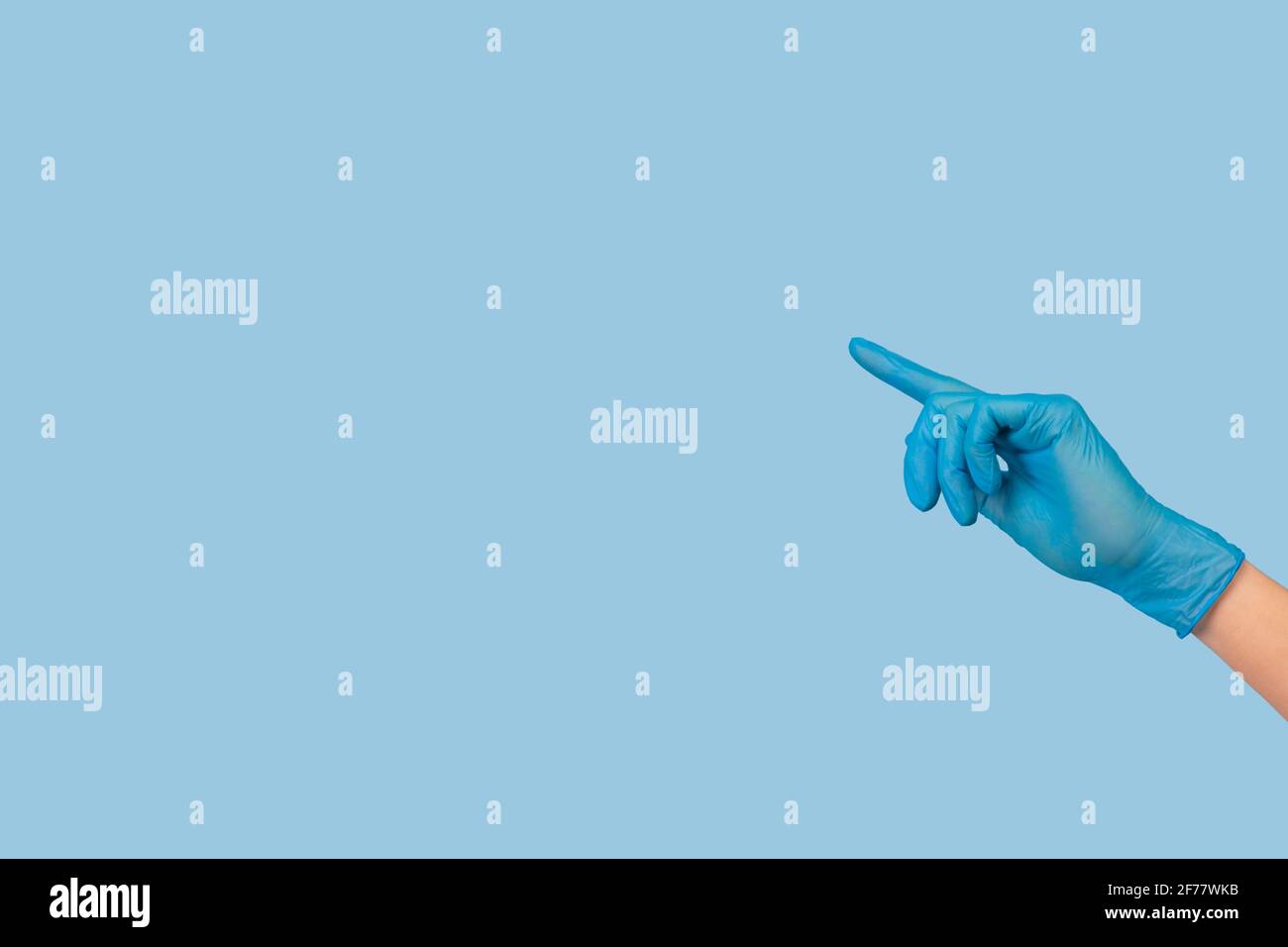 Female hand in blue medical surgical glove pointing on something ...