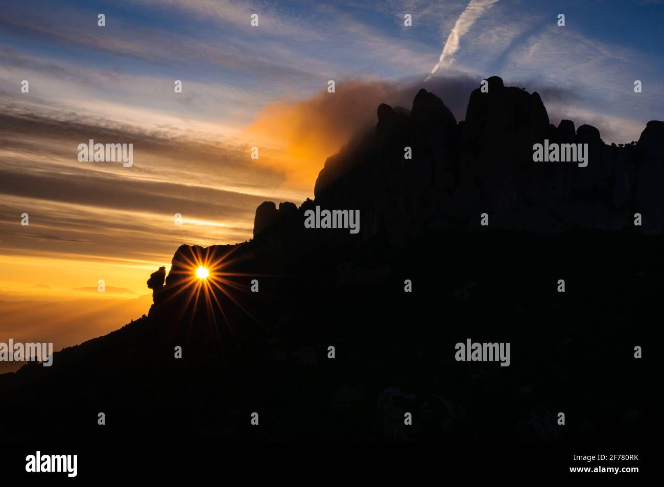 Roca Foradada of Montserrat with the sun rising through the rock hole ...