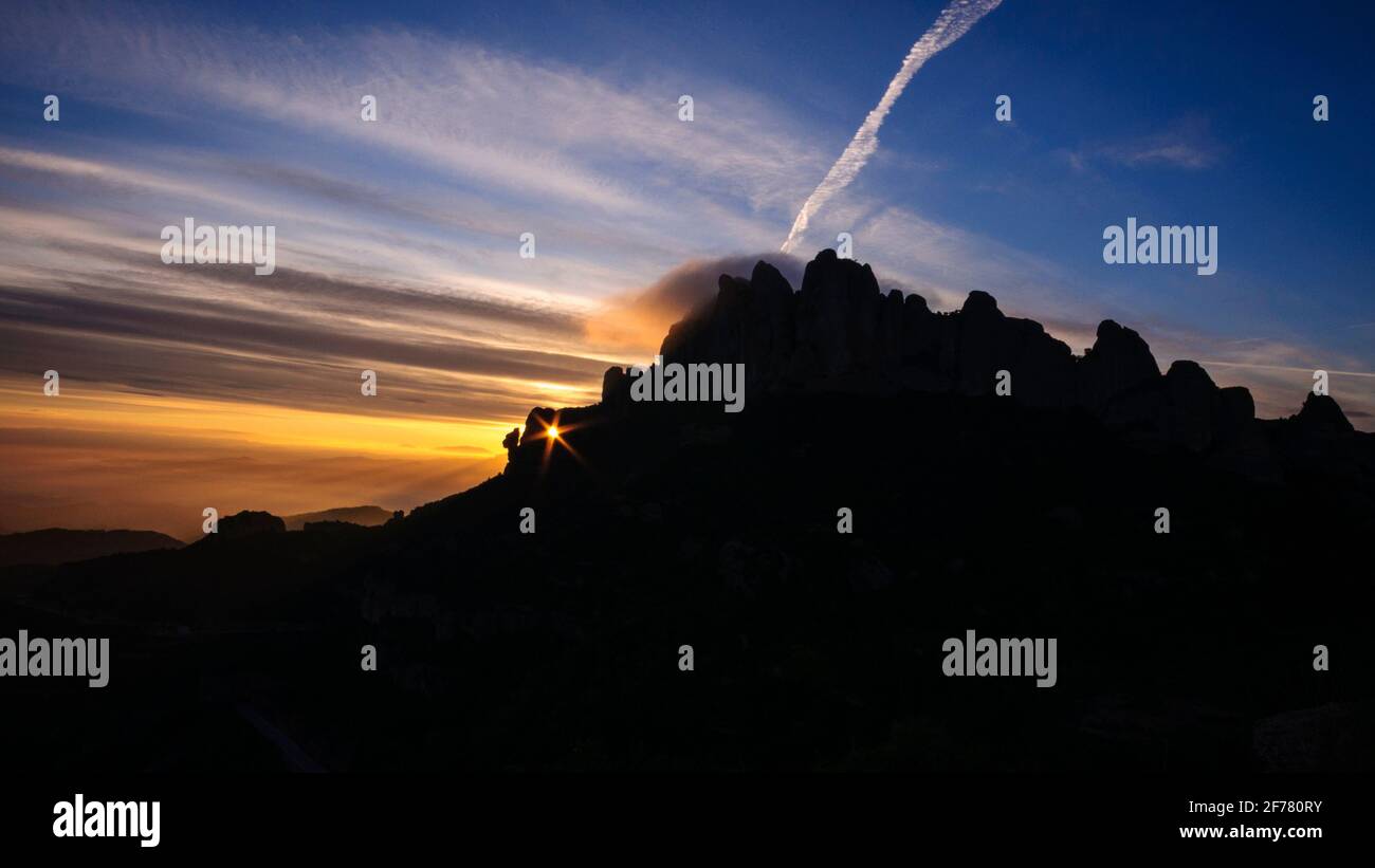 Roca Foradada of Montserrat with the sun rising through the rock hole ...
