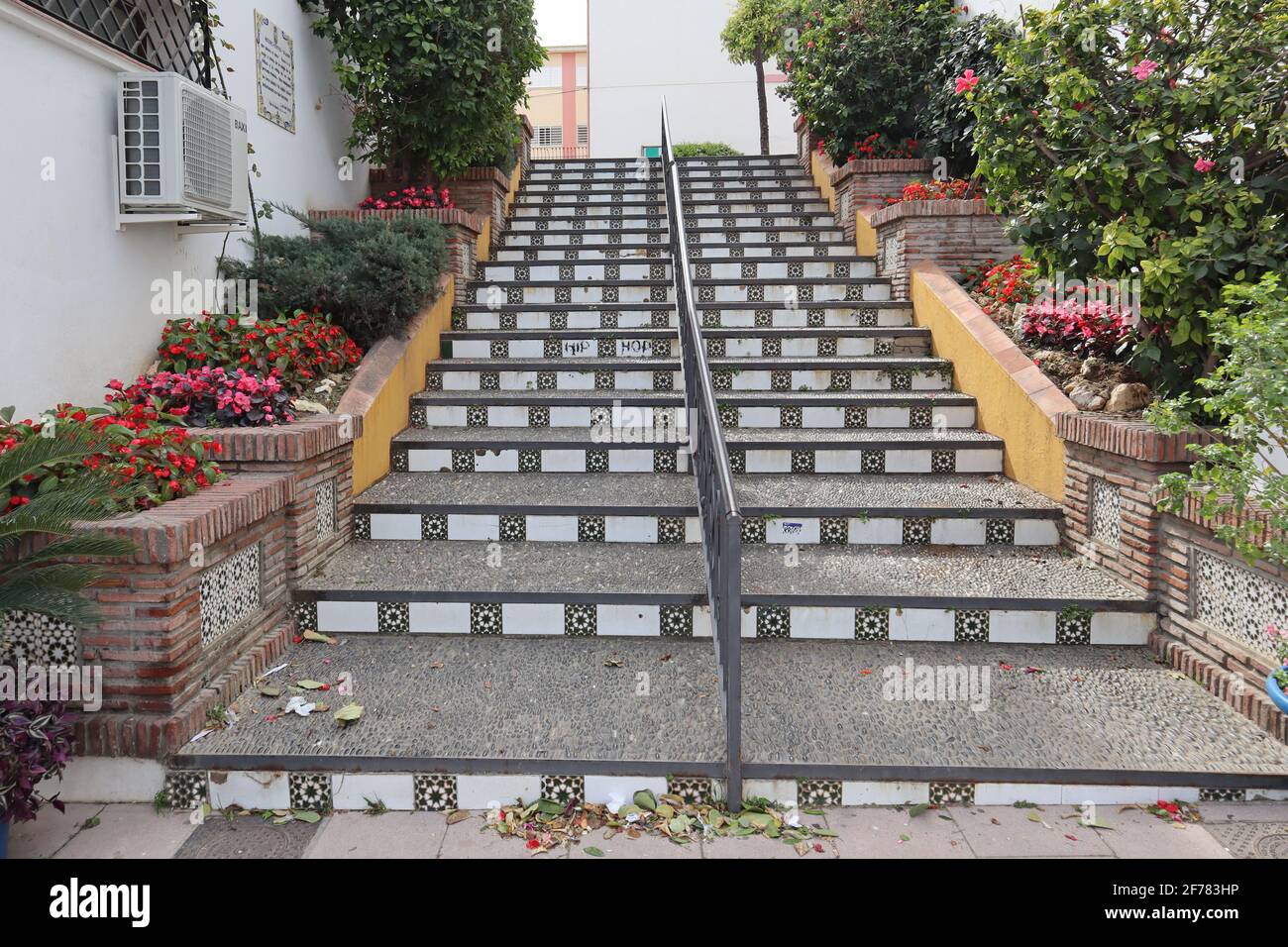 Steps decorated with ceramic tiles lead upwards through brick edged ...