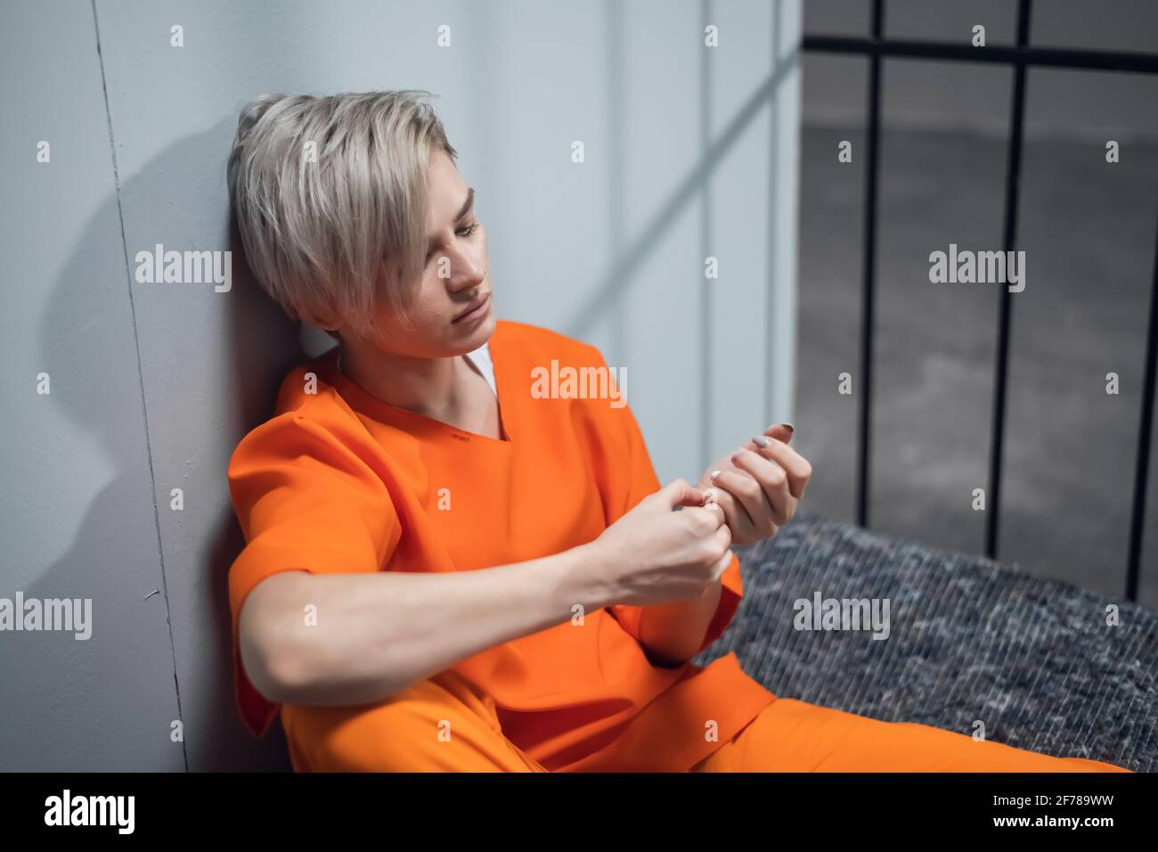 Beautiful girl sitting in a prison cell in an orange robe Stock Photo ...