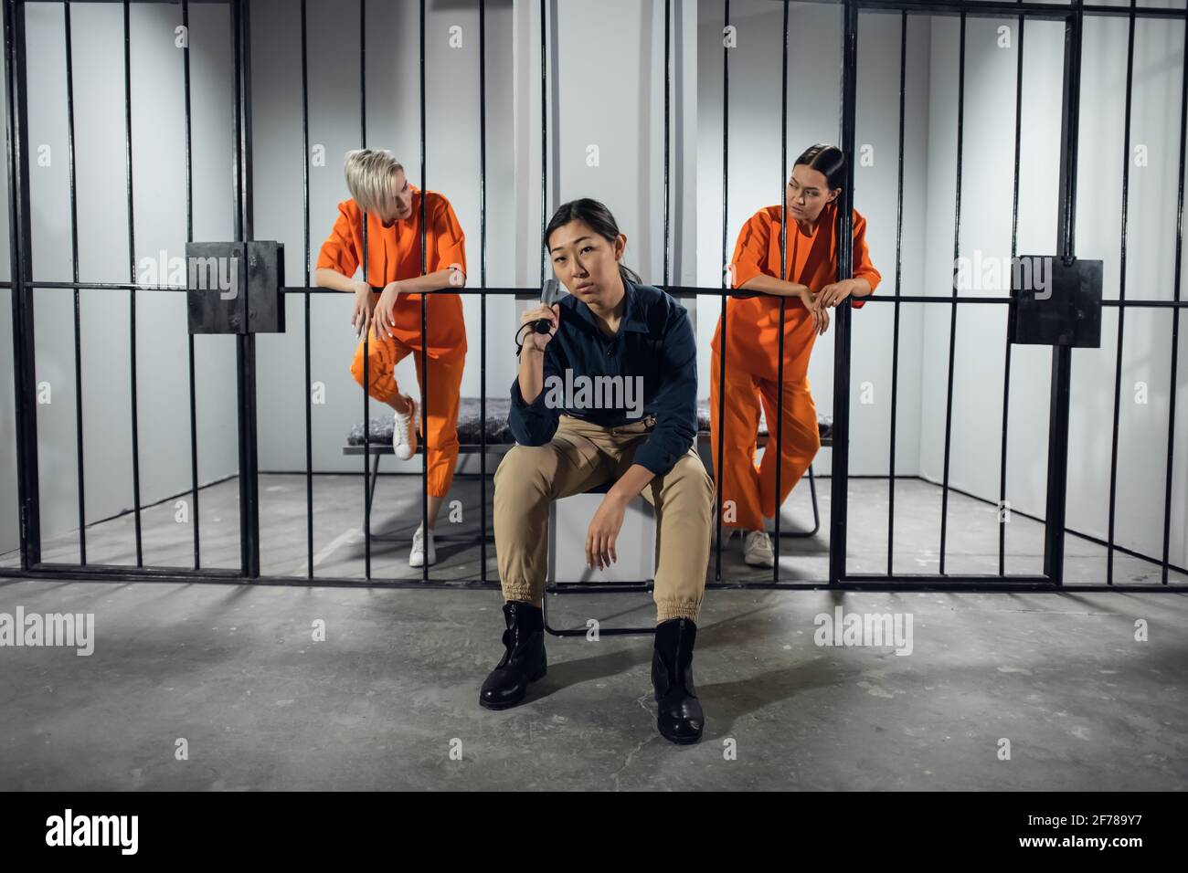 Three girls in a women's prison, a guard and two criminals pose for a ...