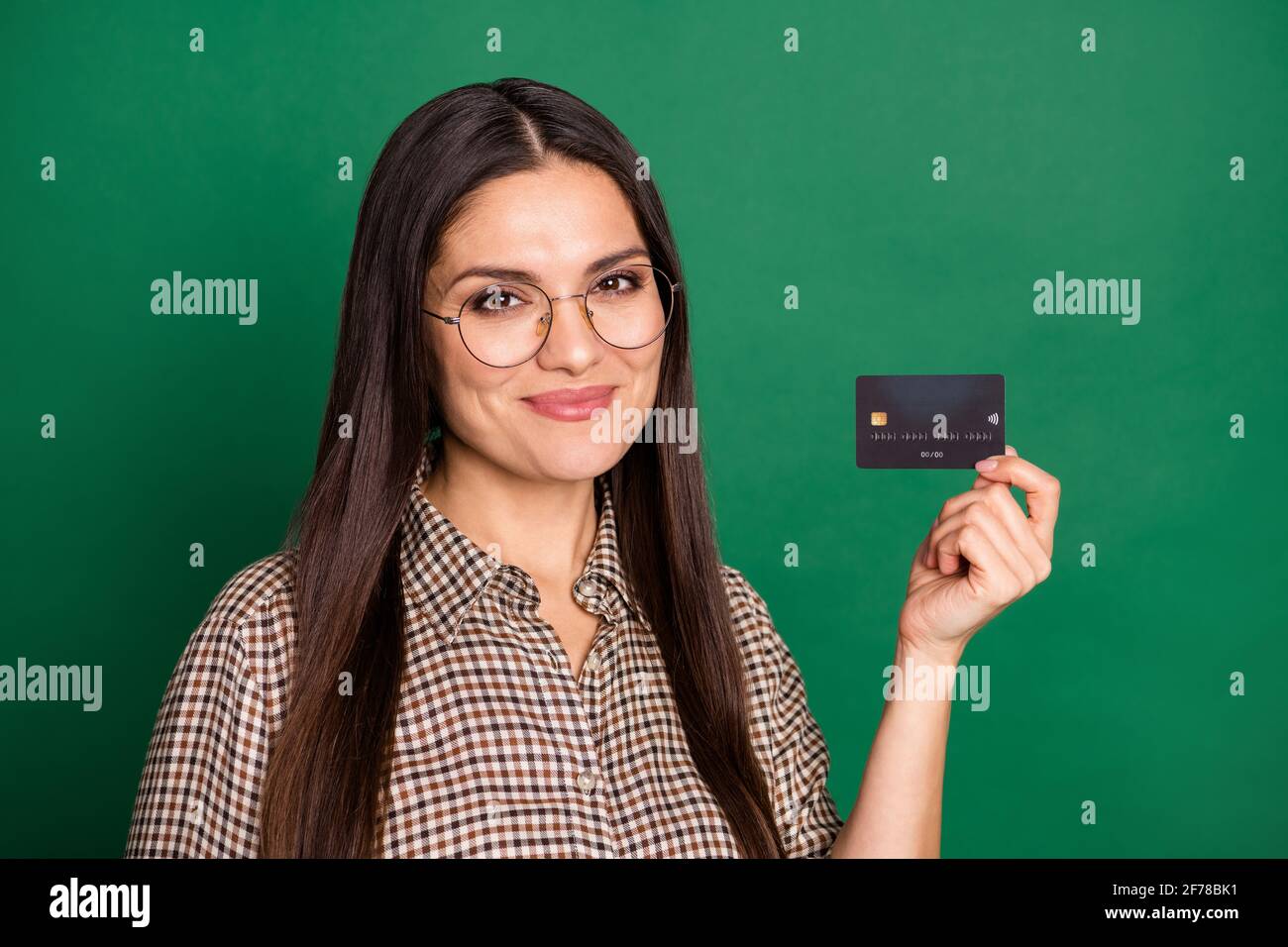 Photo of positive woman presenting credit card wear eyeglasses plaid ...