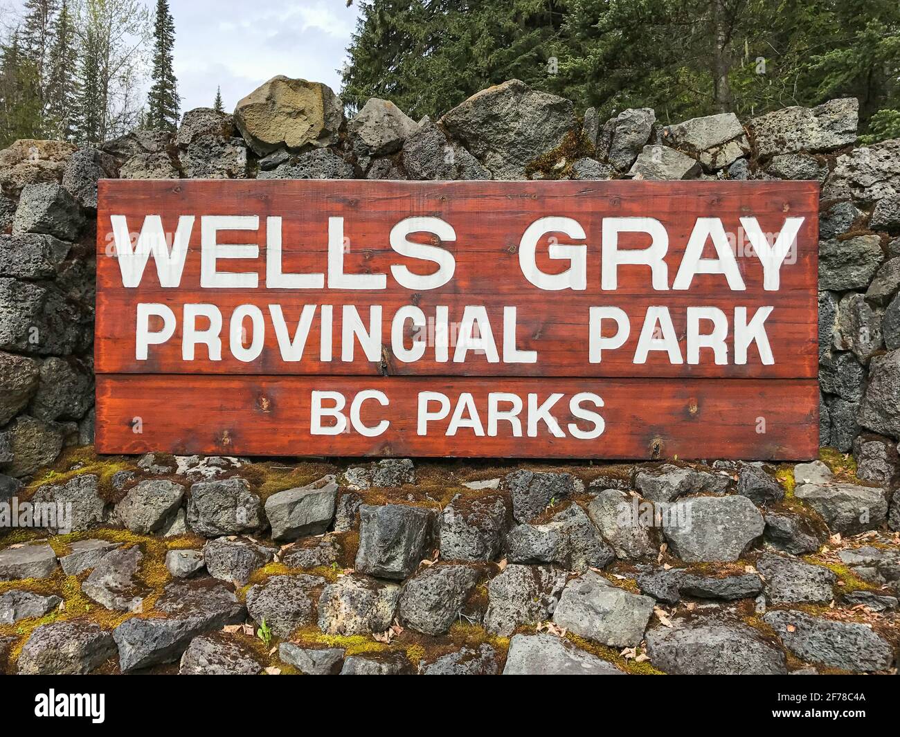 The wooden Wells Gray Provincial Park sign surrounded by rocks near ...