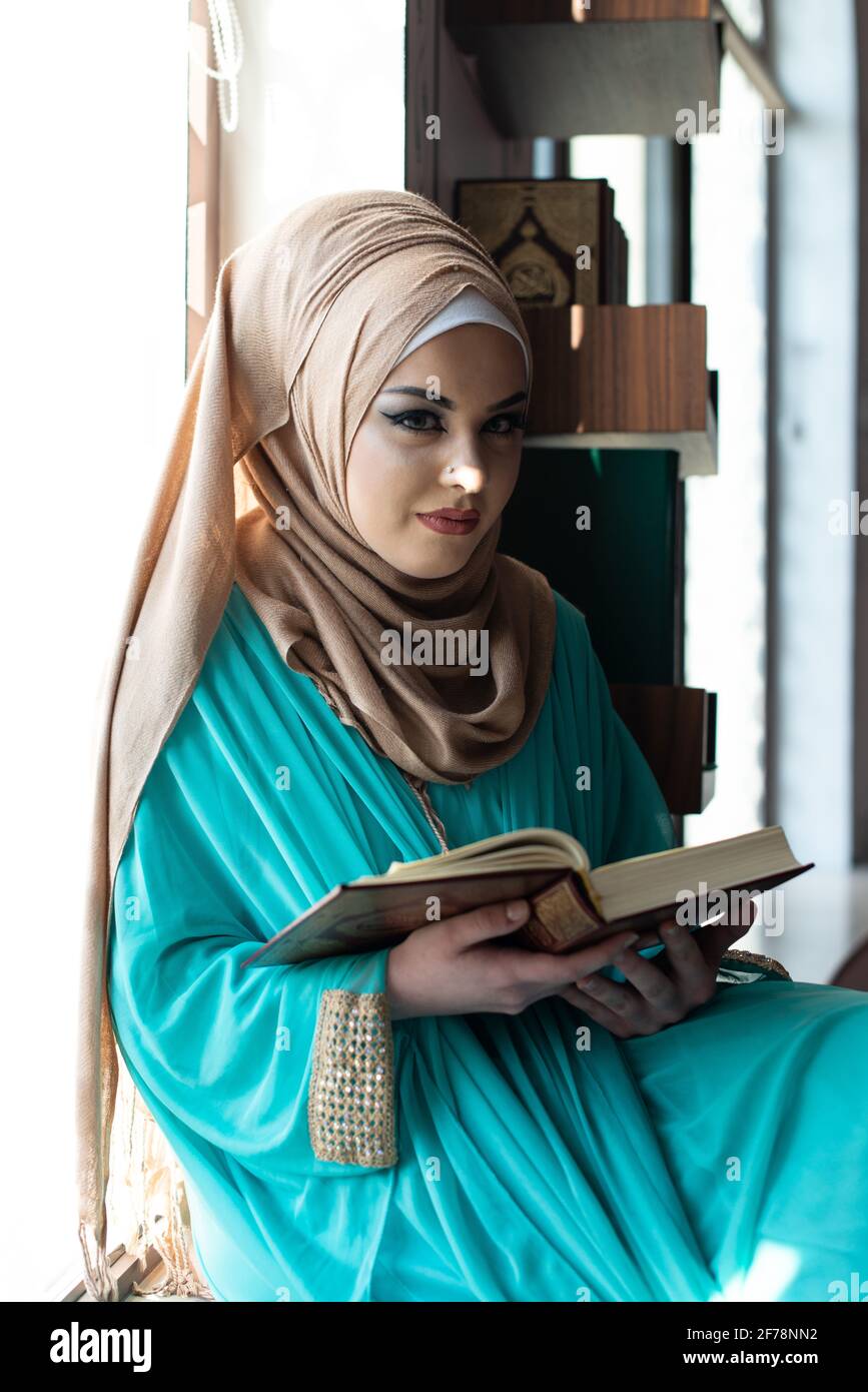 Muslim Woman Reading Koran or Quran Wearing Traditional Dress at the ...