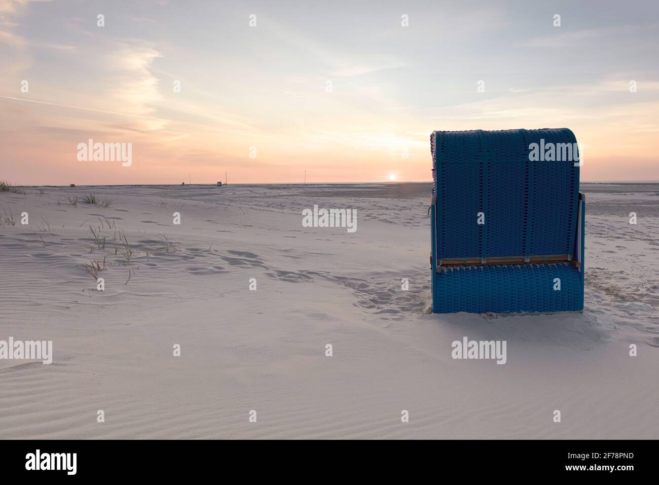 Back view of blue roofed wicker beach chair on empty sand beach at ...