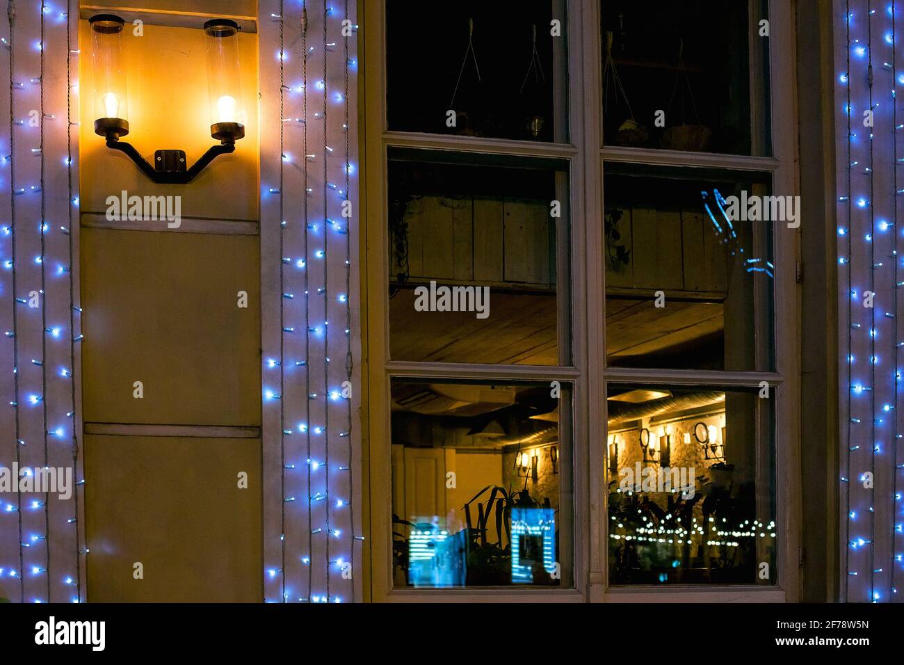 facade of a cafe with a large wooden window with a street lamp and ...