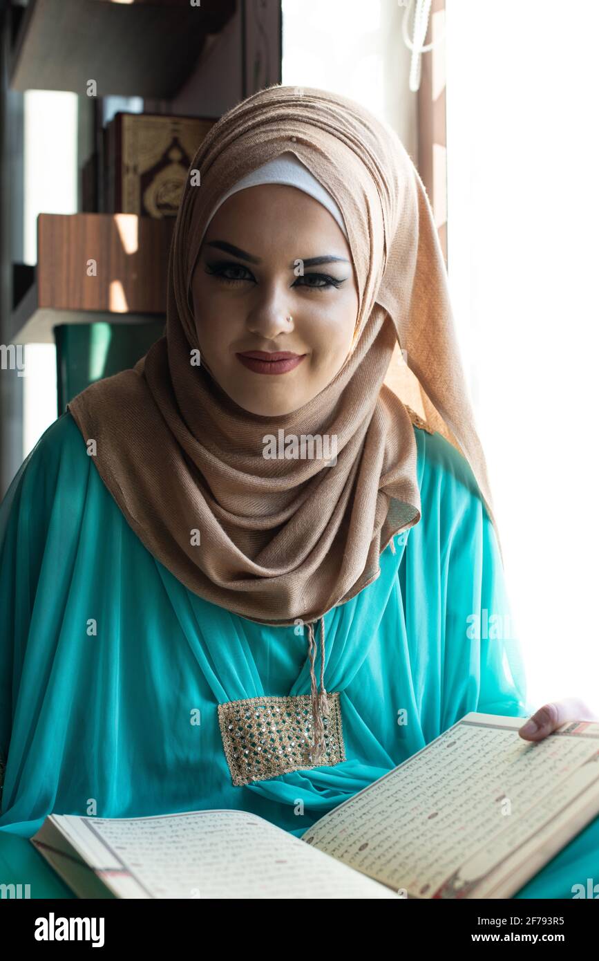 Muslim Woman Reading Koran or Quran Wearing Traditional Dress at the ...