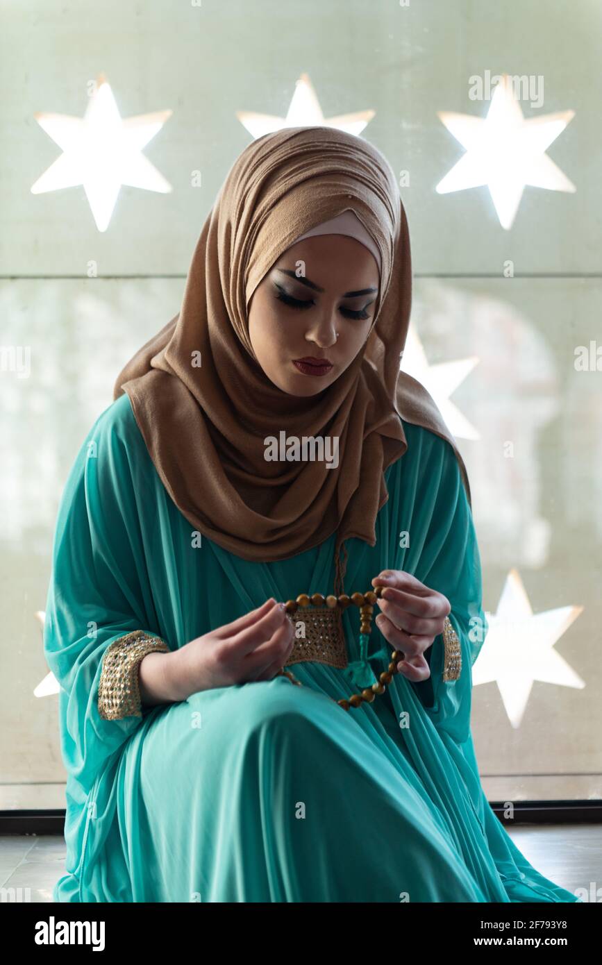 Muslim Woman Wearing Moslem Clothes With Hijab and Rosary Praying in ...