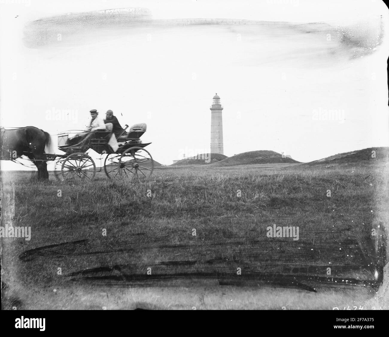 Horse carriage and two people with a lighthouse in the background Stock ...