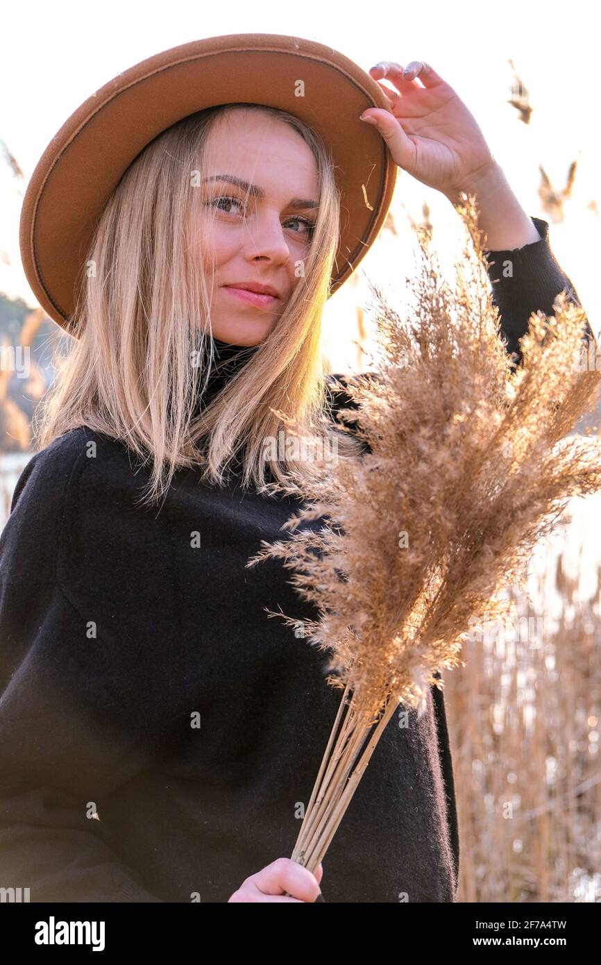 European blonde woman with beige hat in black sweater in the ...