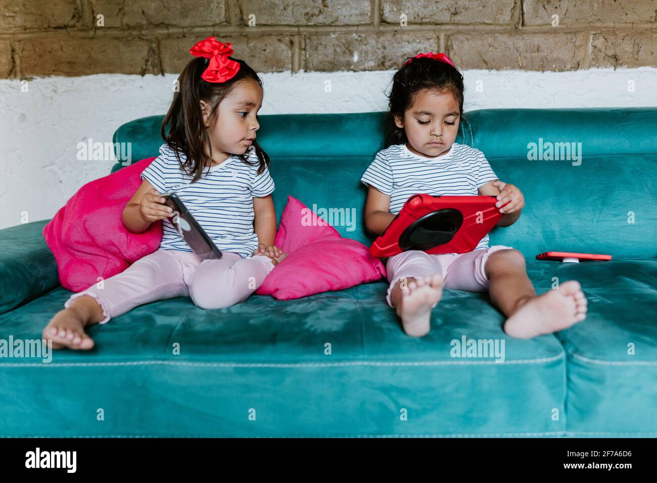 latin child or little girls with phone and tablet at home in Mexico ...