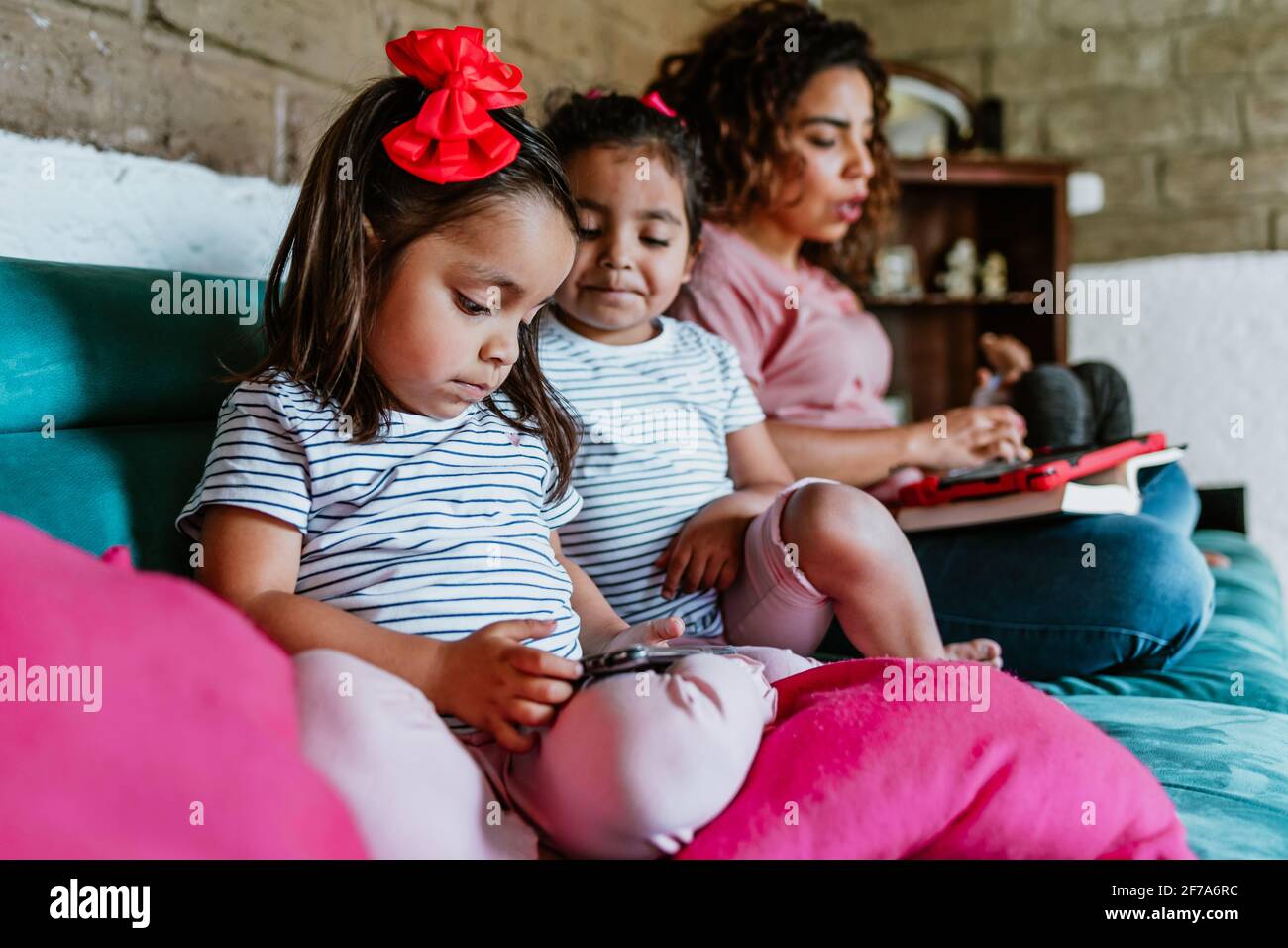 latin child or little girls with phone and tablet at home in Mexico ...