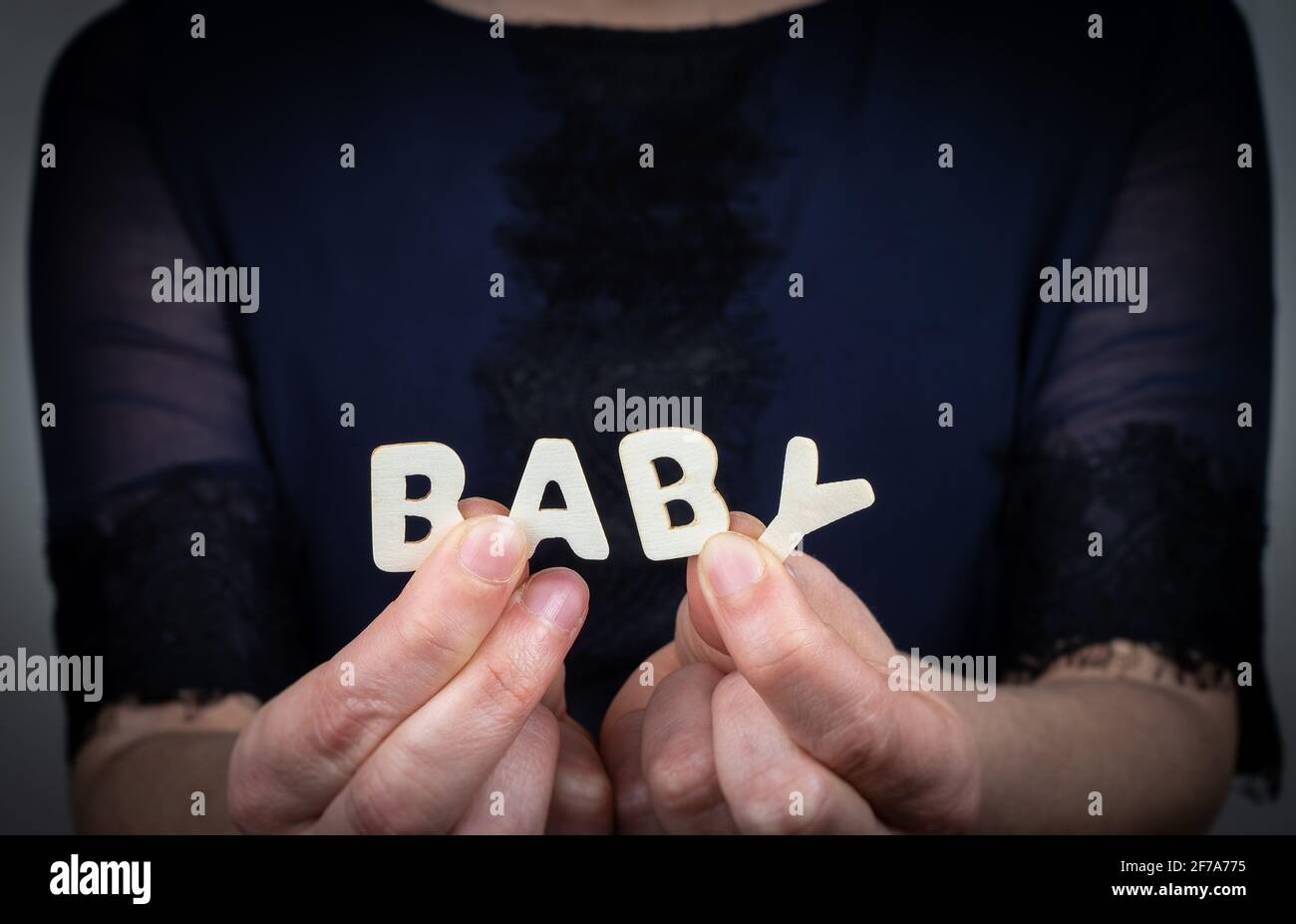 BABY. Word from white letters of wooden alphabet in woman's hand Stock ...
