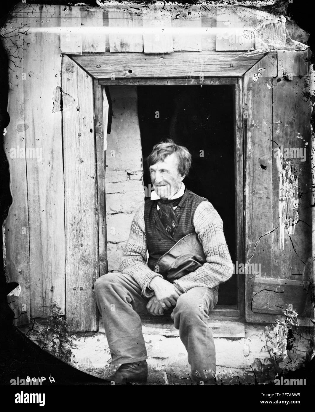 Unknown man seated in a doorway Stock Photo - Alamy