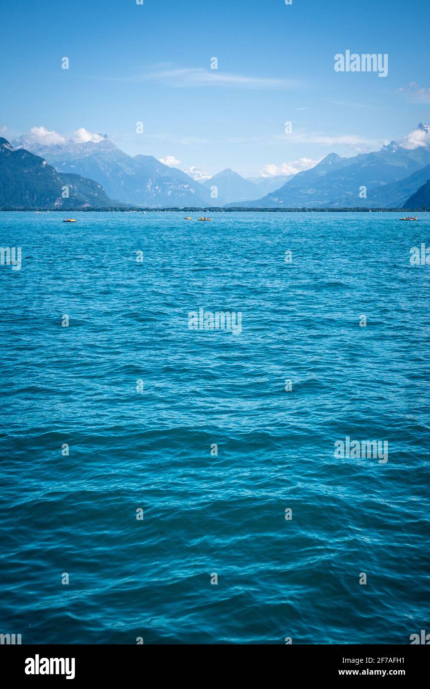 Vertical backdrop of calm lake water and clear blue summer sky with ...