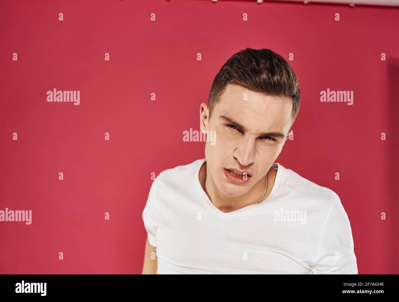 emotional man angry facial expression white t-shirt red background ...