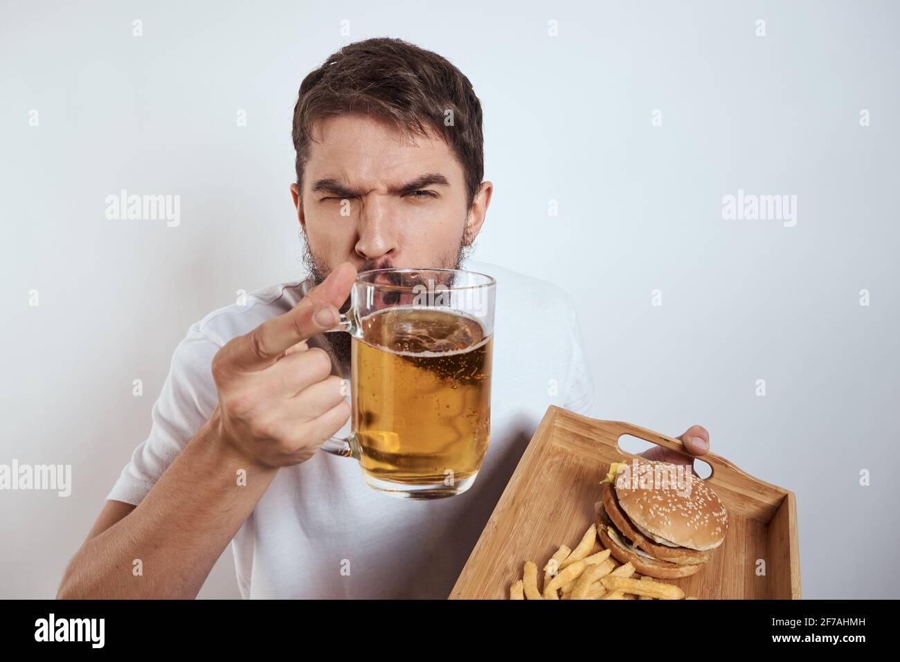 Man with a mug of beer fast food diet food alcohol fun light background ...