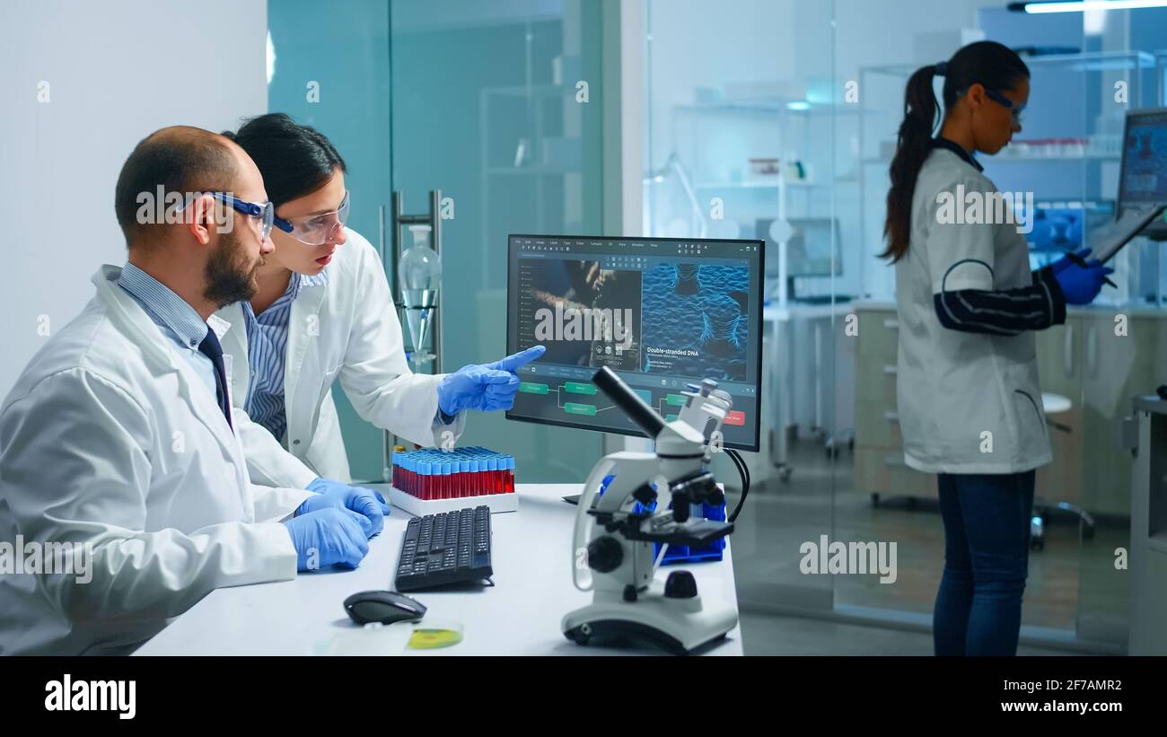 Chemist doctor explaining to coworker vaccine development, DNA ...