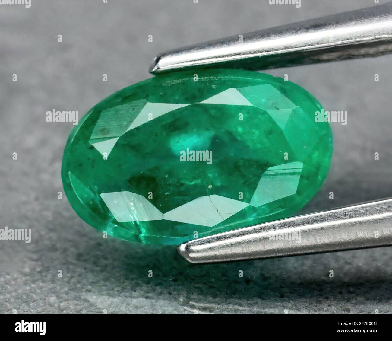Natural gemstone green emerald on gray background Stock Photo - Alamy