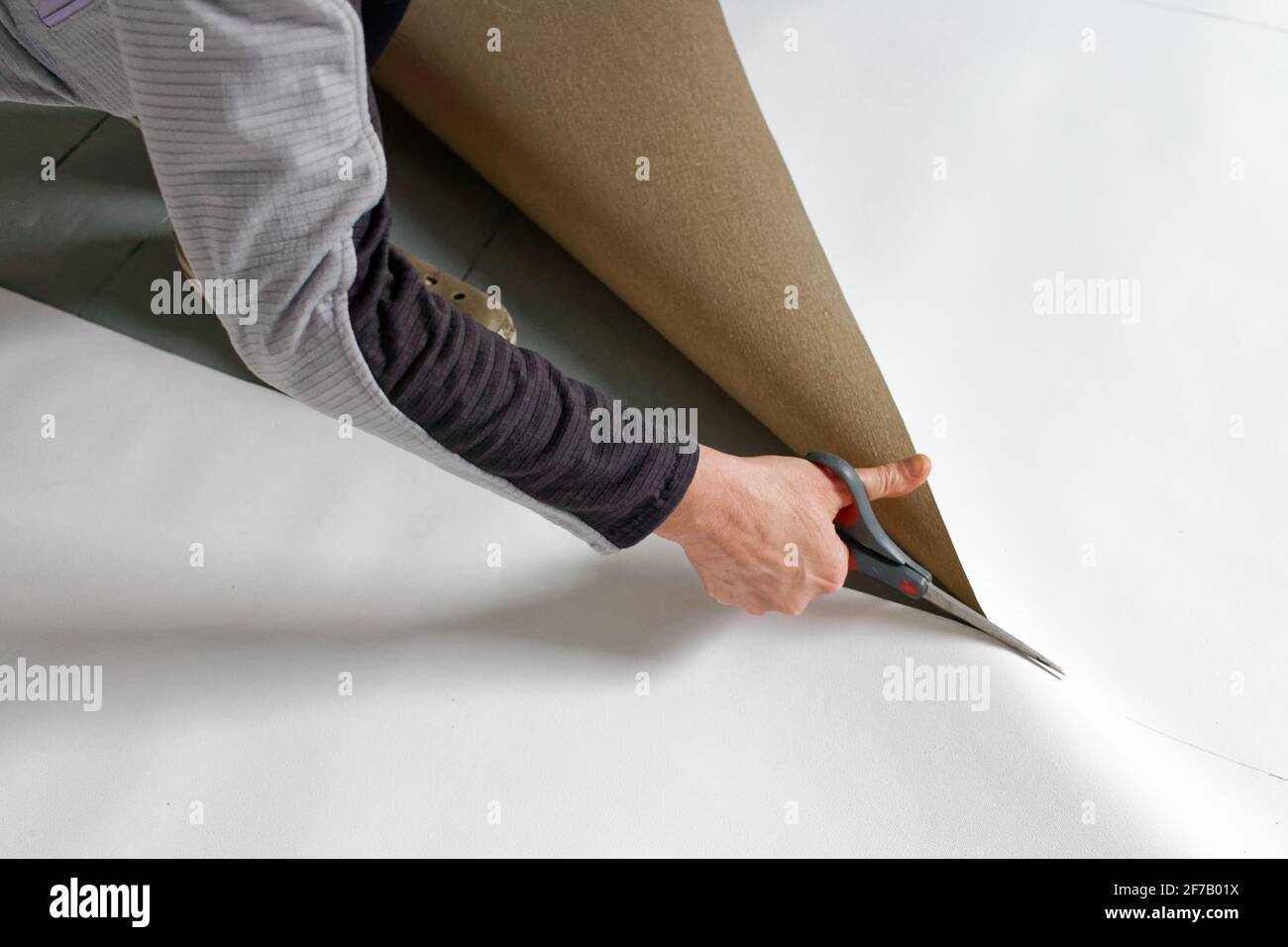 A female artist cutting canvas to prepare her own picture supports ...