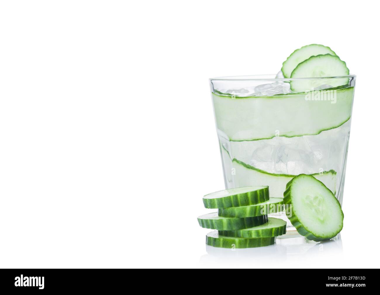 Fresh cold cucumber water with ice cubes and cucumber slices on white ...