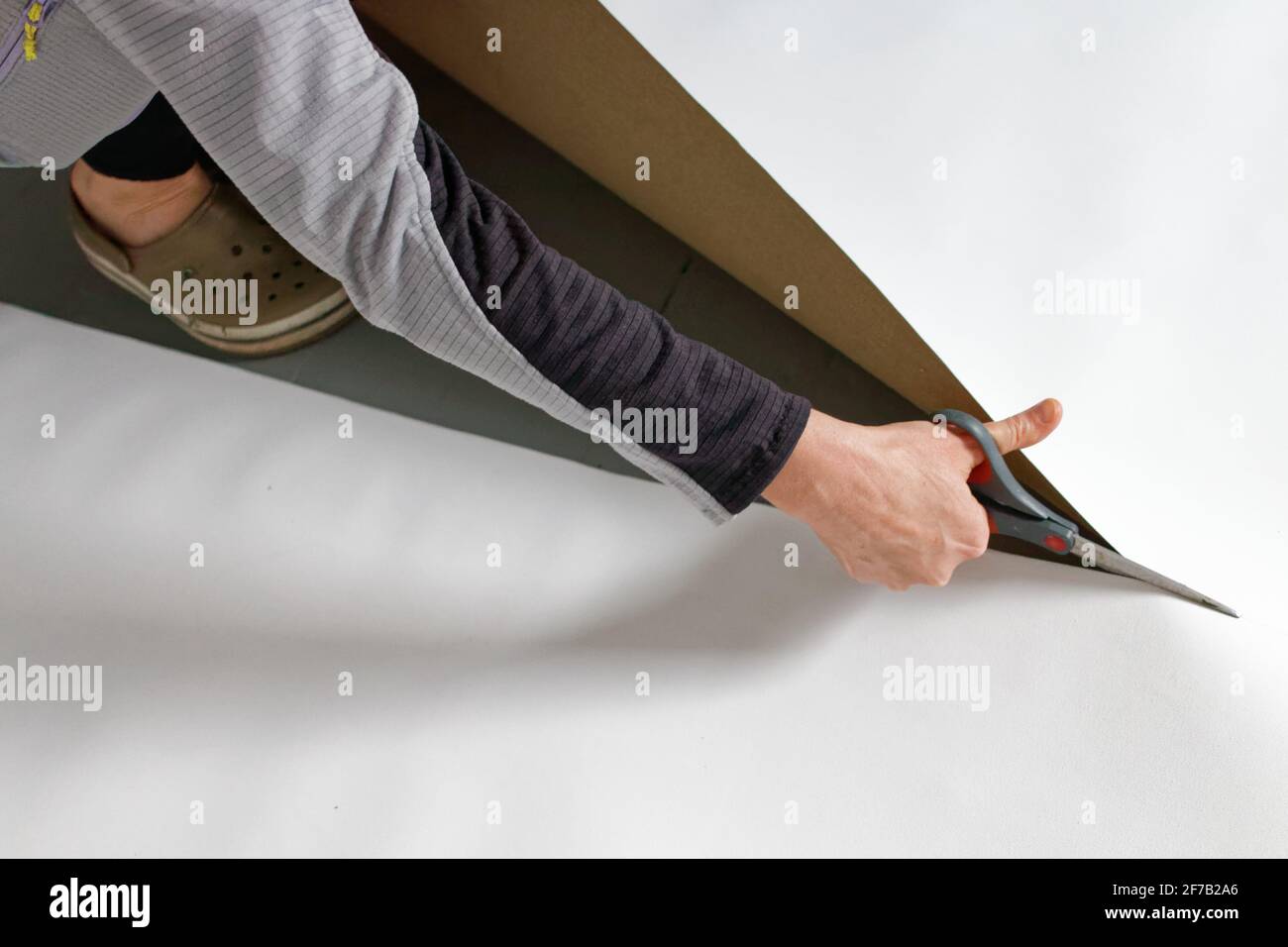 A female artist cutting canvas to prepare her own picture supports ...