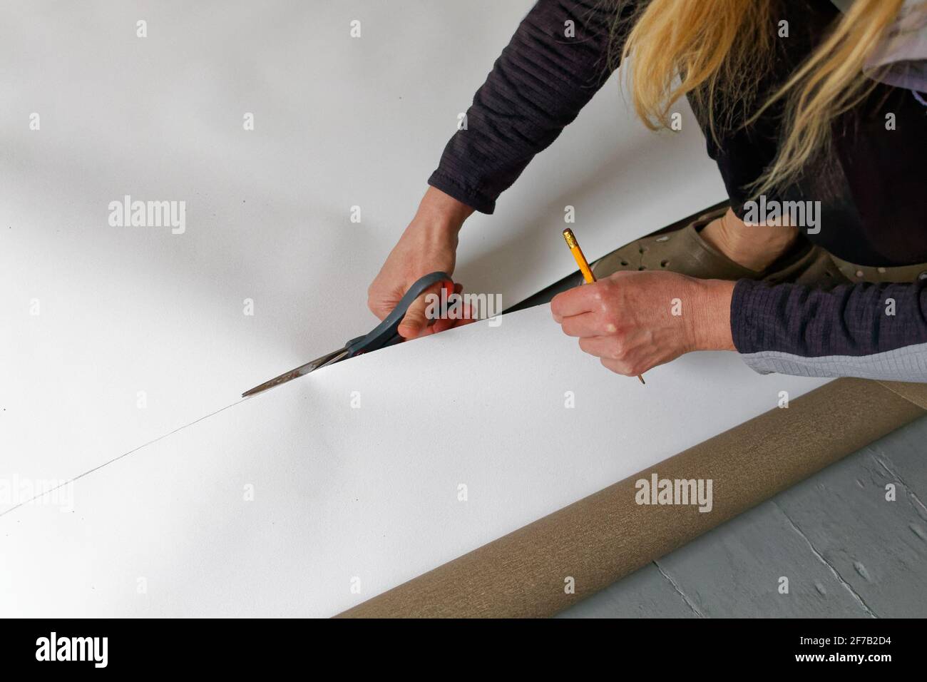 A female artist cutting canvas to prepare her own picture supports ...