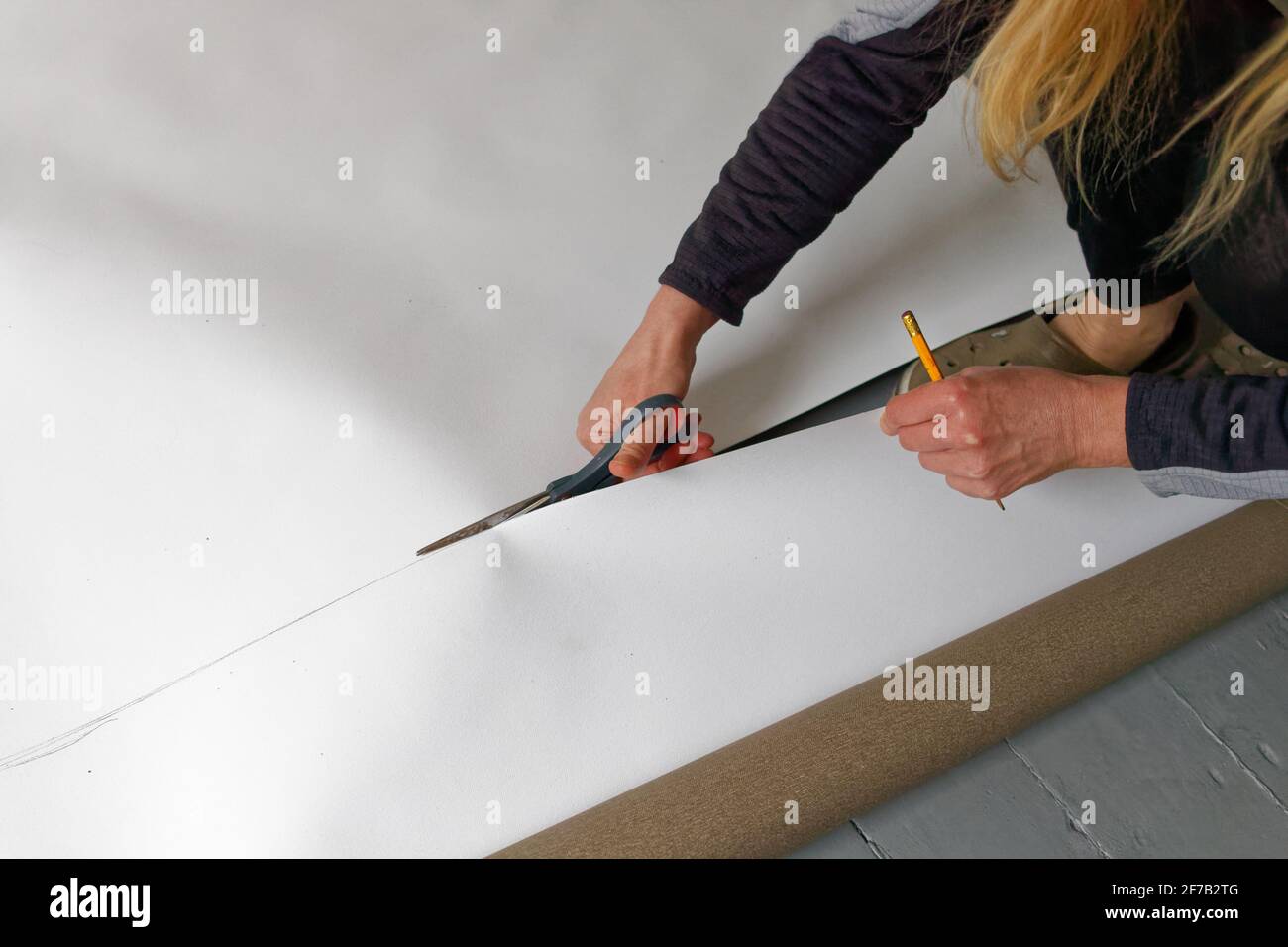 A female artist cutting canvas to prepare her own picture supports ...