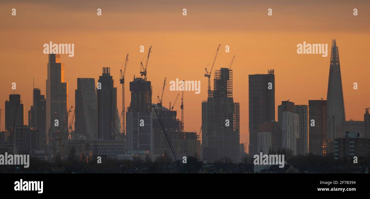 6 April 2021. Orange sky at sunrise behind City of London skyscrapers ...