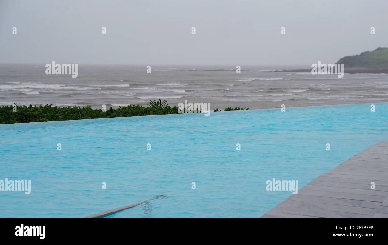 An infinity pool by the ocean on a wet and rainy grey overcast day ...
