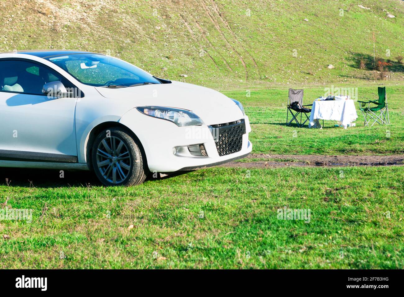 Picnic near the car . Table and chairs at green grass Stock Photo - Alamy