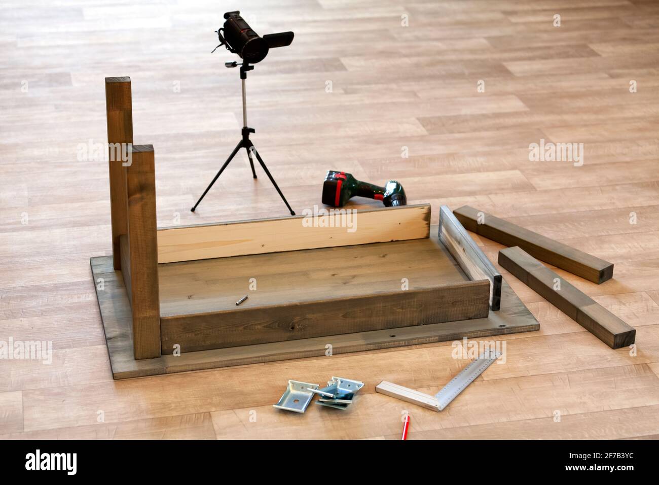 Online assembling of a wooden table. Video camera shooting a process of ...