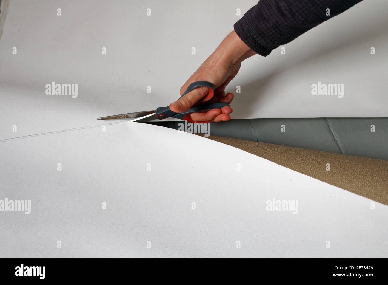 A female artist cutting canvas to prepare her own picture supports ...