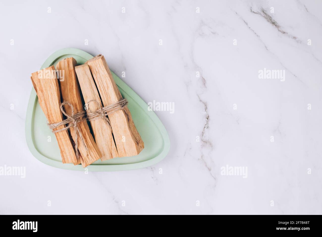 Palo Santo tree sticks on green concrete tray against light marble ...