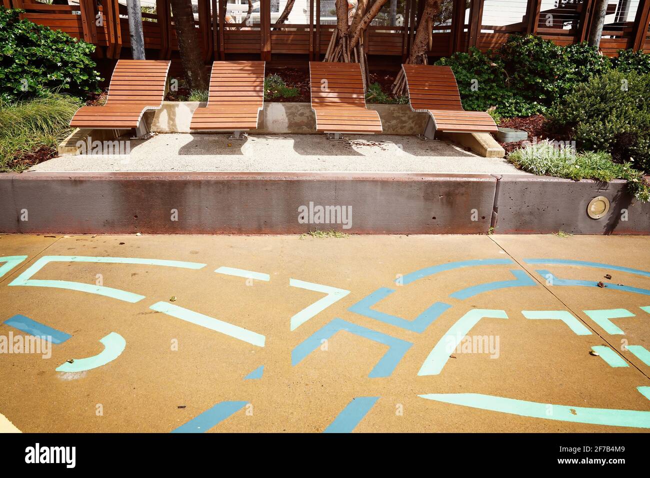 Timber tourist loungers beside a colorfully painted footpath on the ...