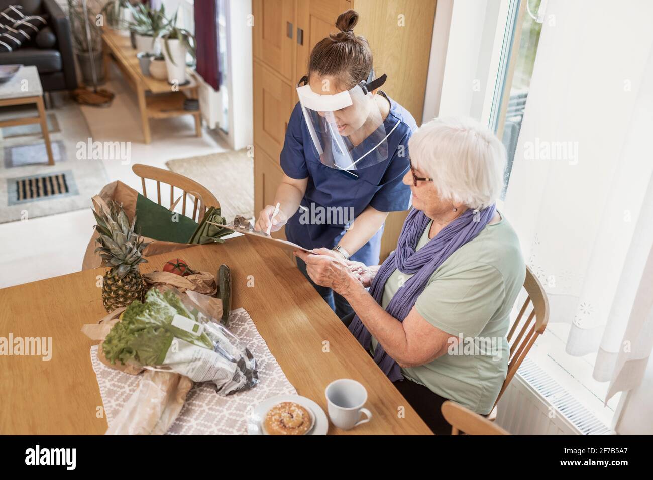 Home carer helping senior woman at home Stock Photo - Alamy