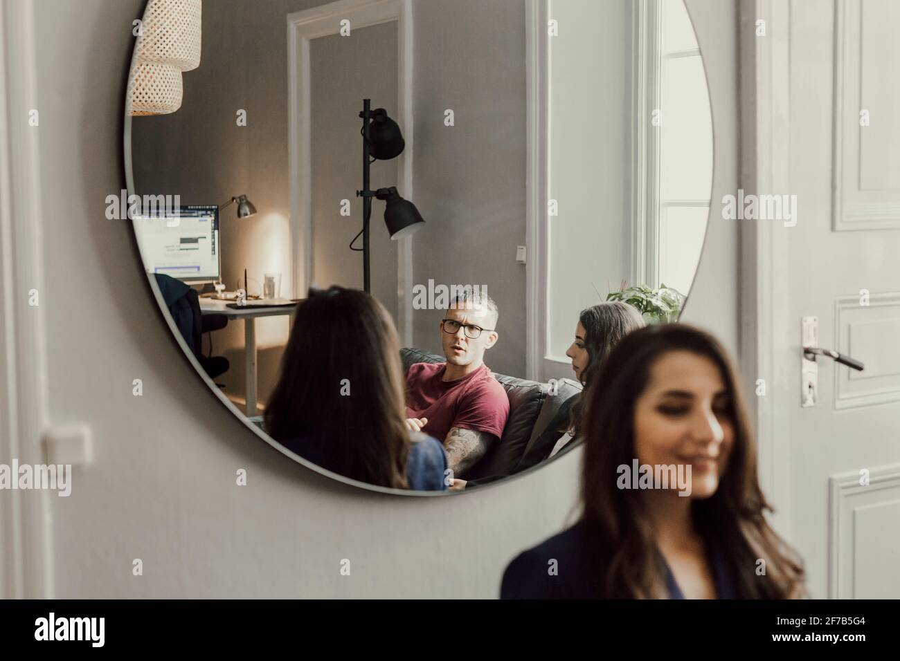 Reflection in mirror of coworkers during meeting Stock Photo - Alamy
