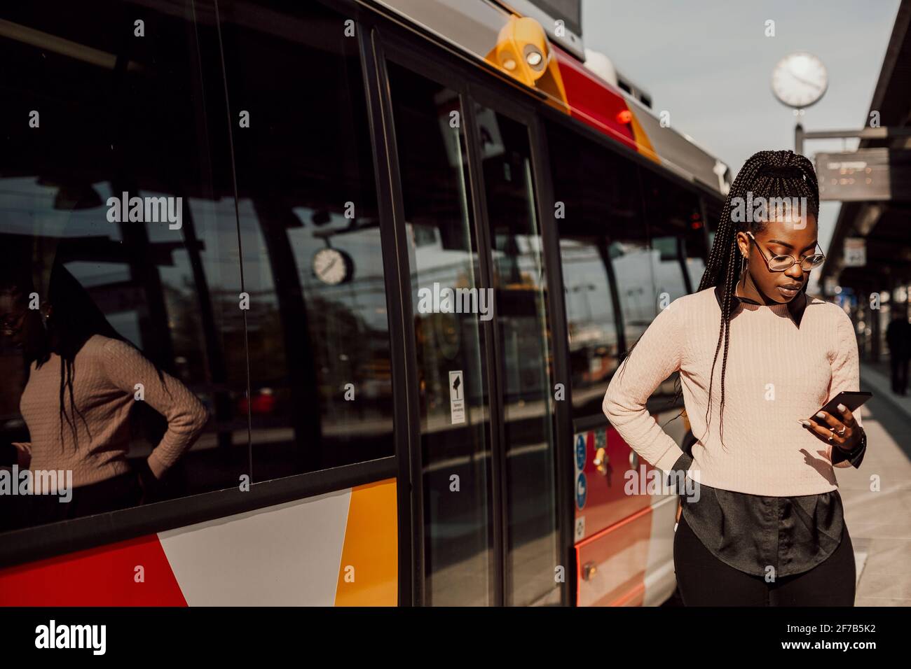 Young woman waiting at bus station Stock Photo - Alamy