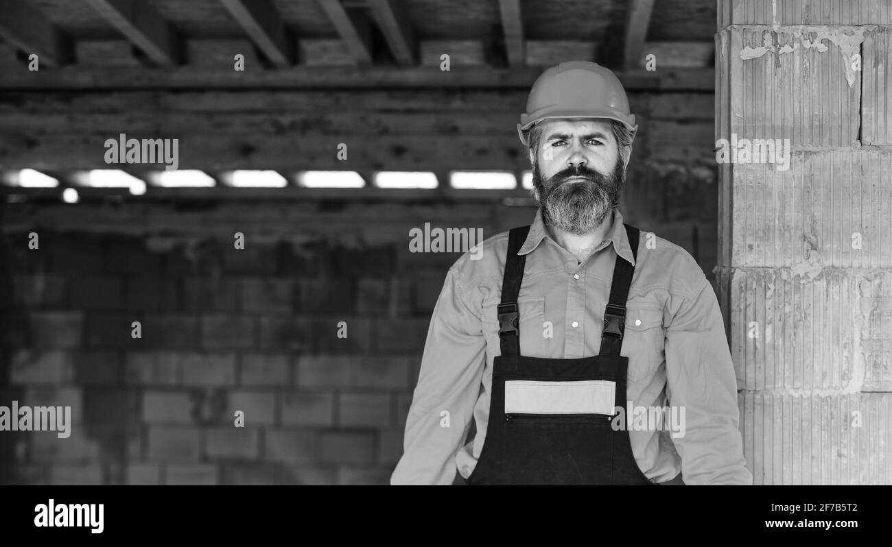mature bearded man in hard hat. man builder in an unfinished building ...