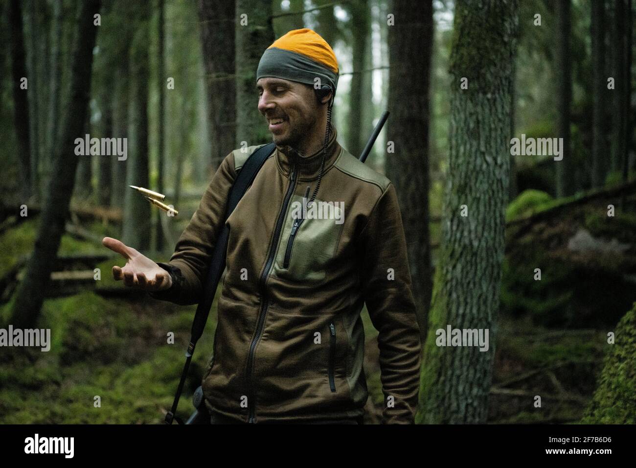 Hunter in forest throwing bullets Stock Photo - Alamy