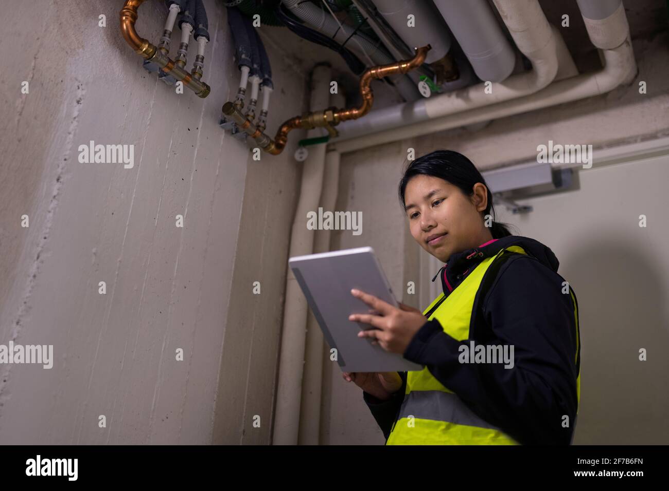 Female plumber checking pipes Stock Photo - Alamy