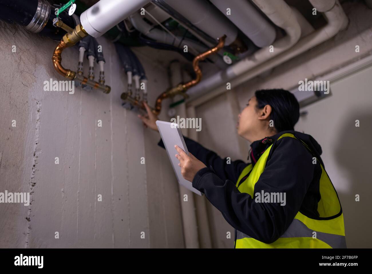 Female plumber checking pipes Stock Photo - Alamy