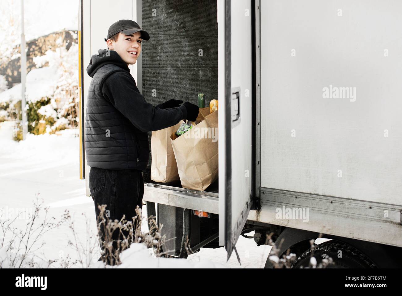Man unloading grocery from car trunk Stock Photo - Alamy