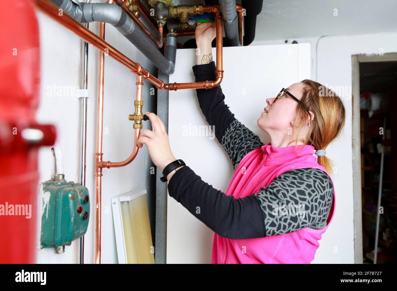 Female plumber checking pipes Stock Photo - Alamy