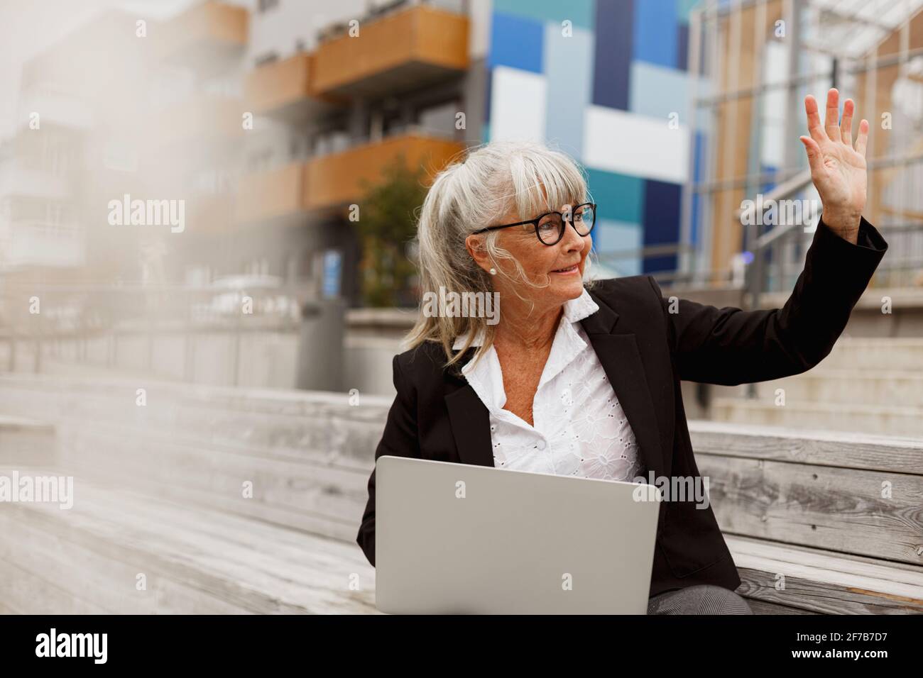 Senior woman waving Stock Photo - Alamy