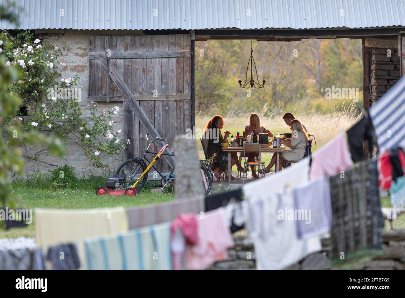 Friends having meal in barn Stock Photo - Alamy