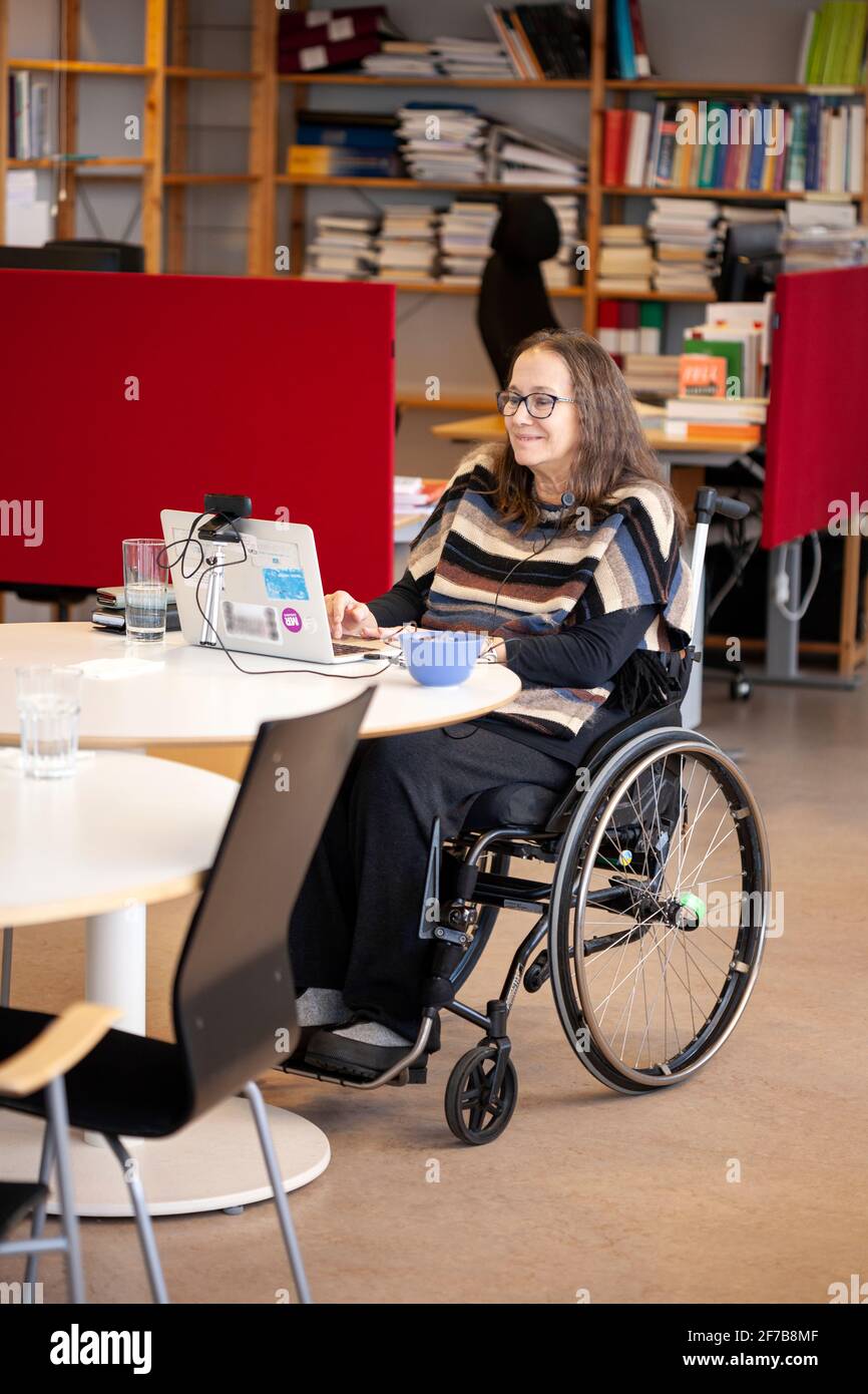 Disabled woman working in office Stock Photo - Alamy