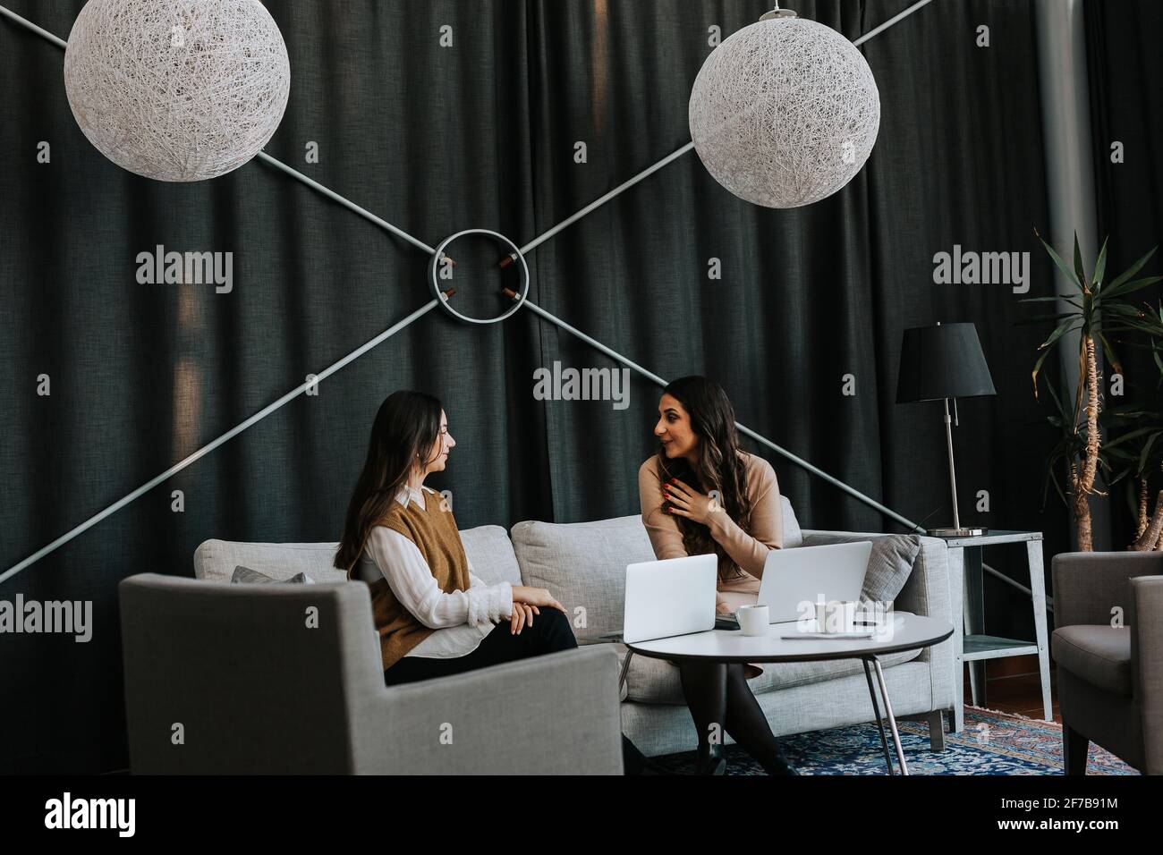 Female coworkers talking Stock Photo - Alamy