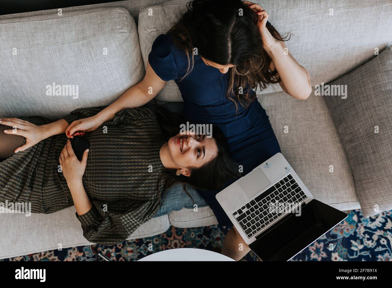 Female coworkers working on sofa Stock Photo - Alamy